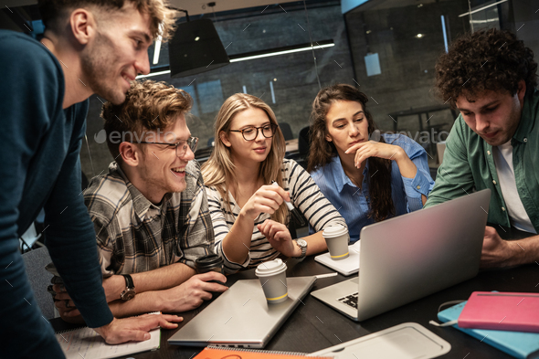 Programmers work alongside their colleagues in an office Stock Photo by milanzeremski